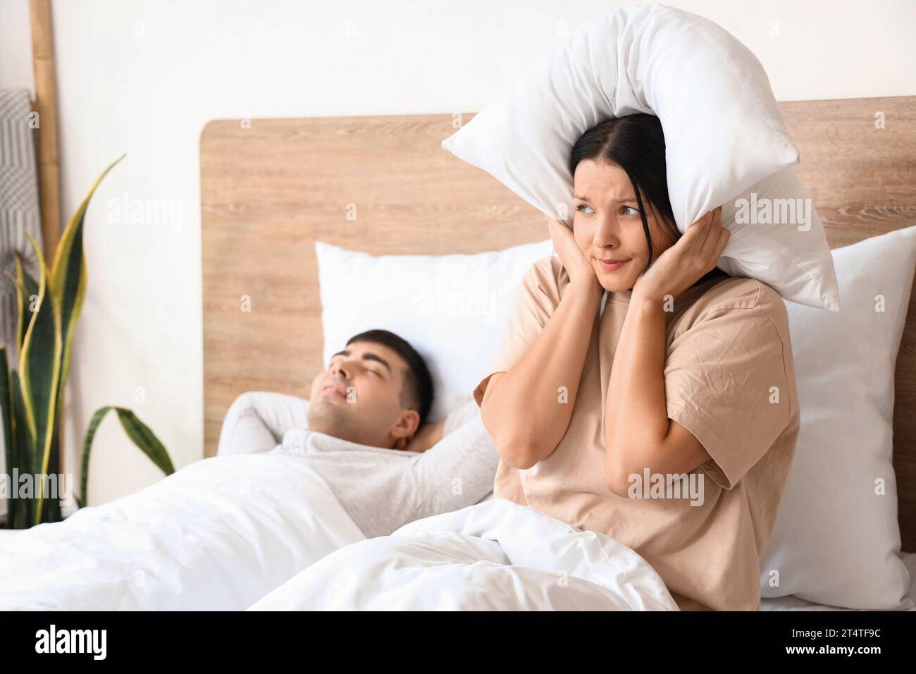 Young woman suffering from her snoring boyfriend in bedroom Stock Photo ...