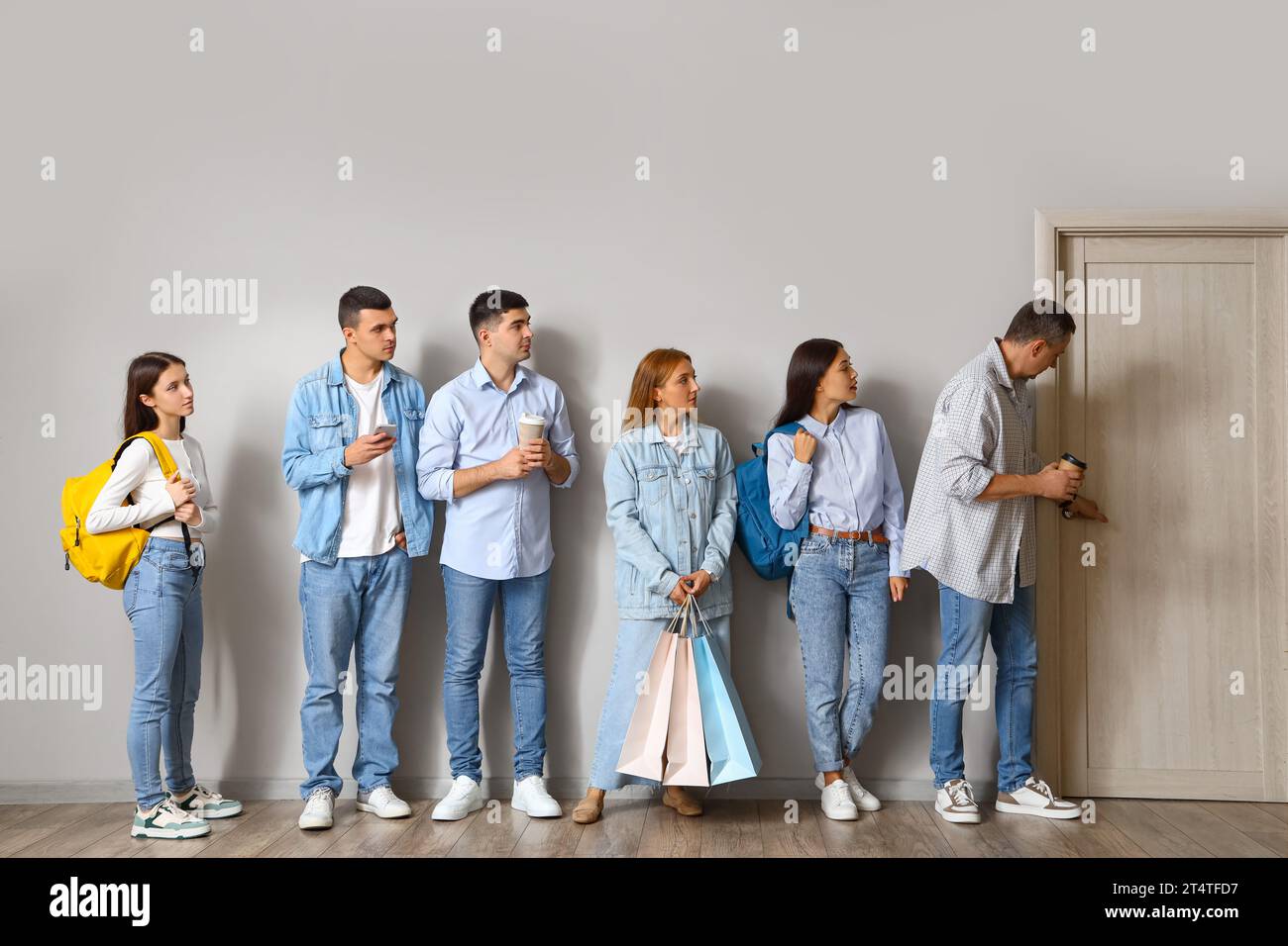 People standing in line near light wall Stock Photo - Alamy