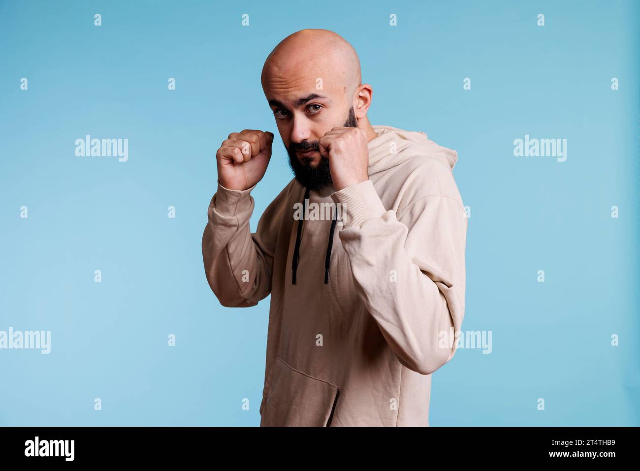 Young arab man standing in aggressive pose with clenched fists, ready ...