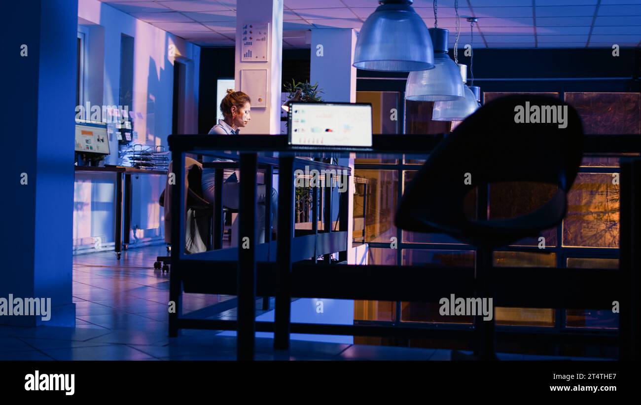 Executive assistant leaving desk job after hours, working late at night ...