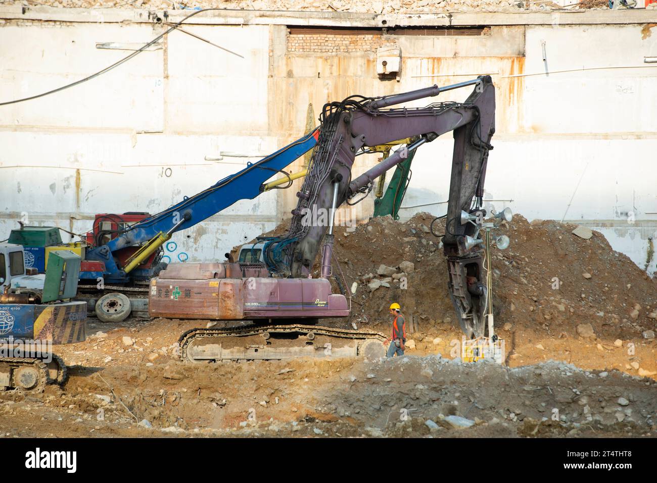Excavator demolishing a old building block Stock Photo - Alamy