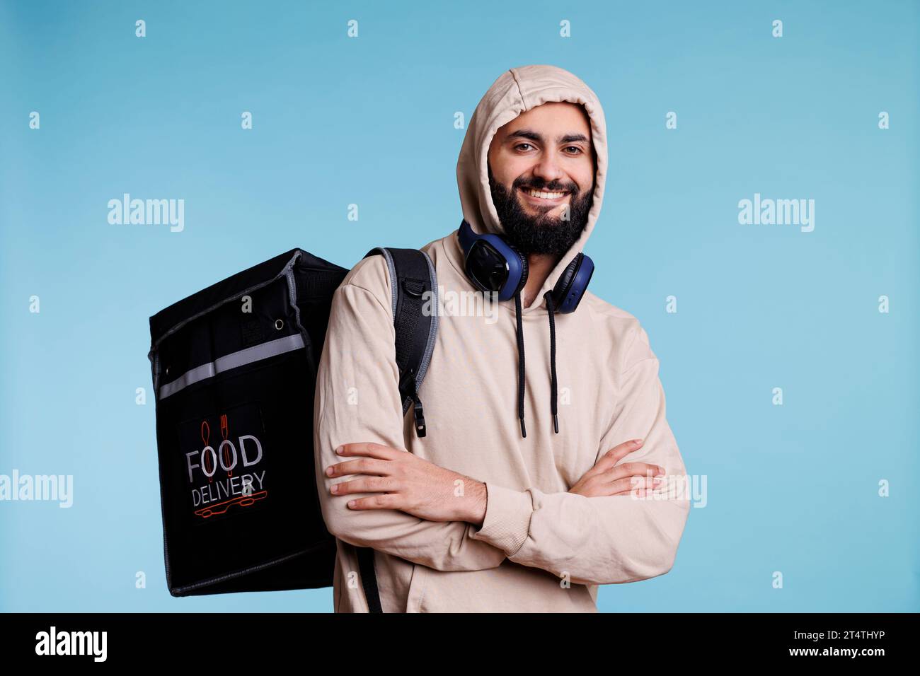 Arab man with cheerful expression carrying backpack and delivering food ...