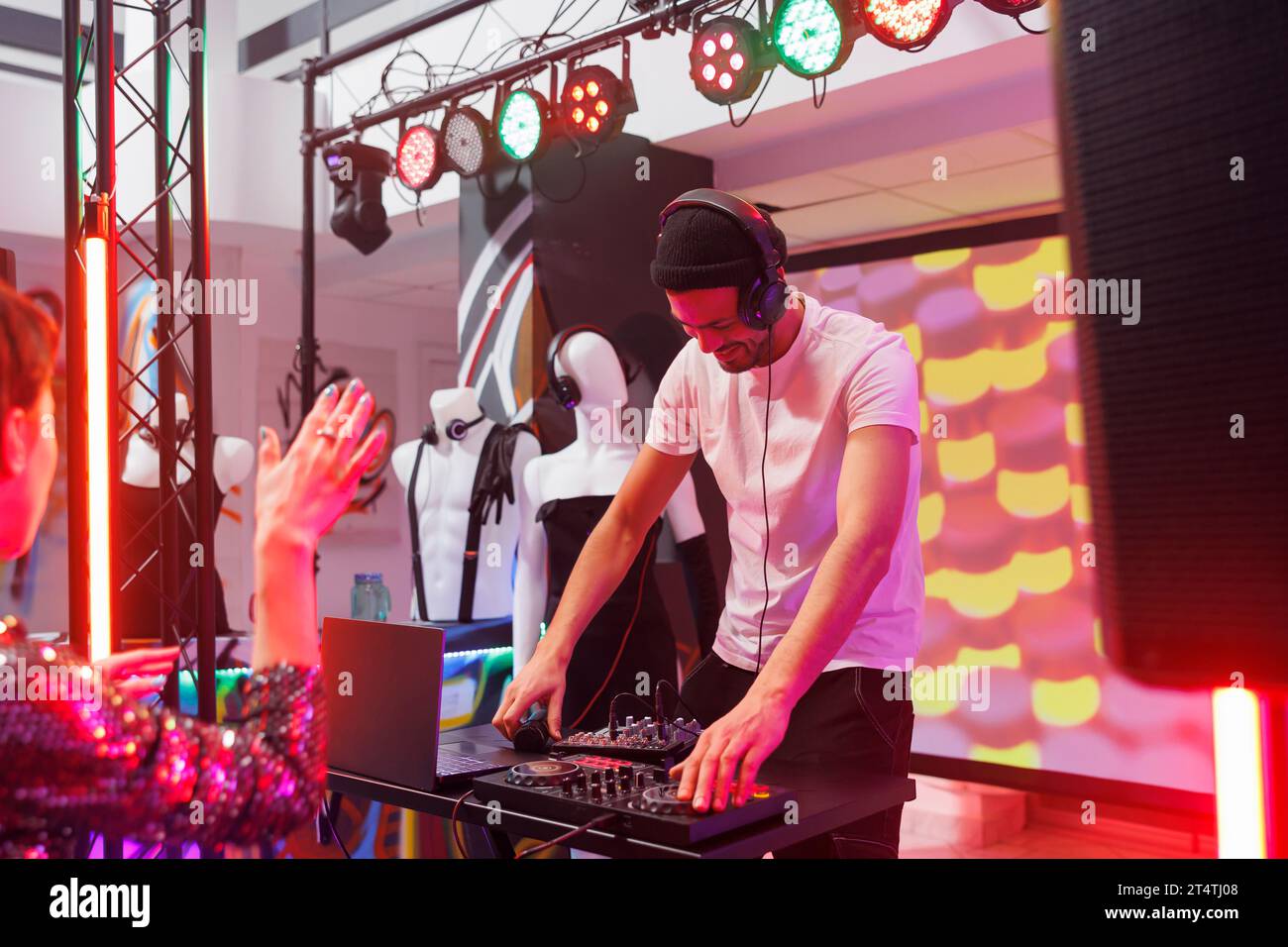 Smiling musician mixing electronic tracks with dj station for people ...