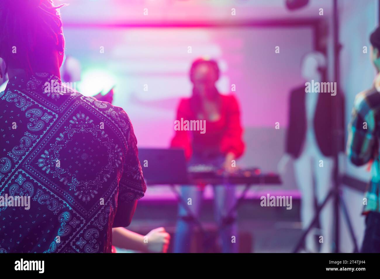 People watching live electronic music concert on stage with spotlights ...