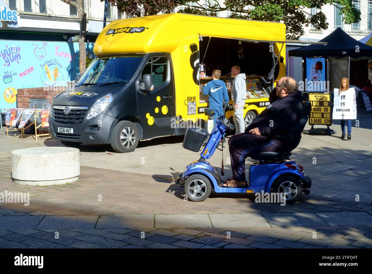 older mature male sat on mobility scooter vaping in front of mobile ...