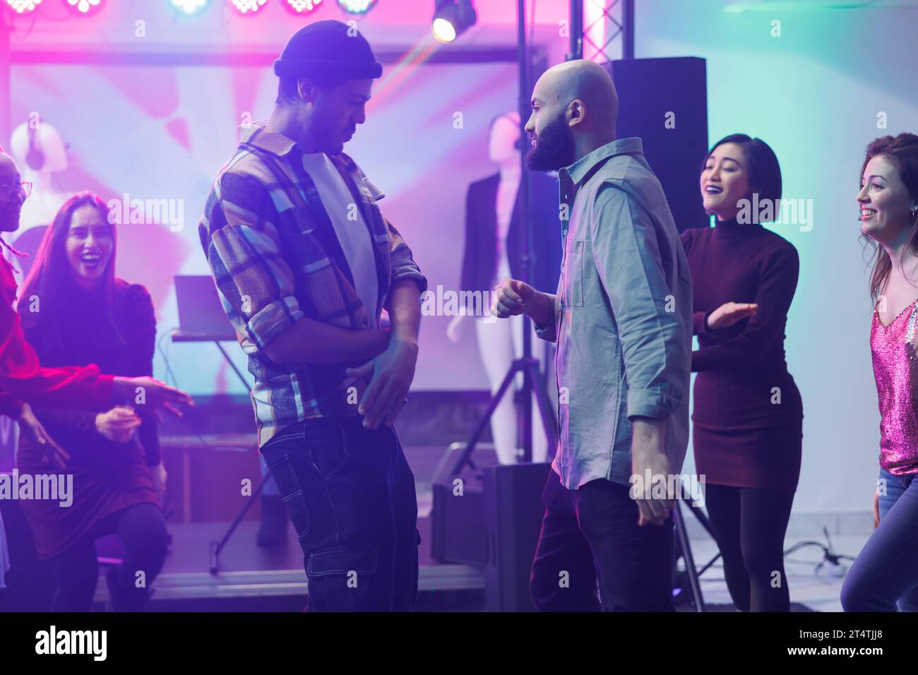 Friends improvising breakdance battle while partying at discotheque in ...