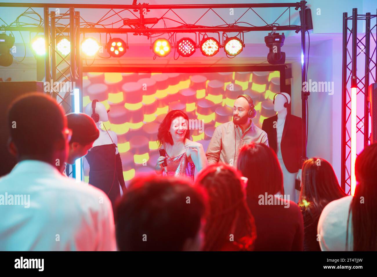 Singer and dj band performing on stage while crowd clubbing at dance ...