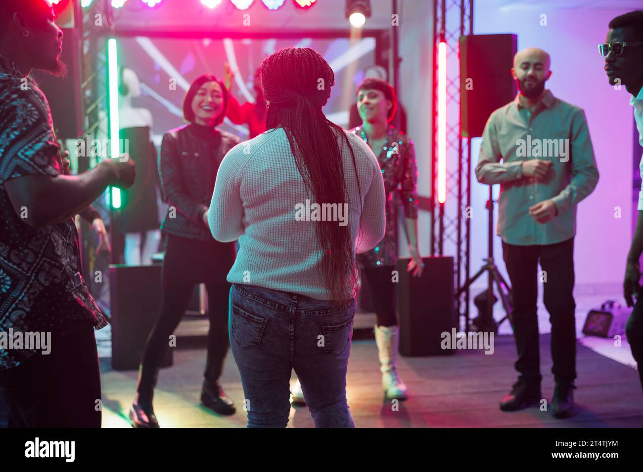 People laughing and dancing together while partying in nightclub ...