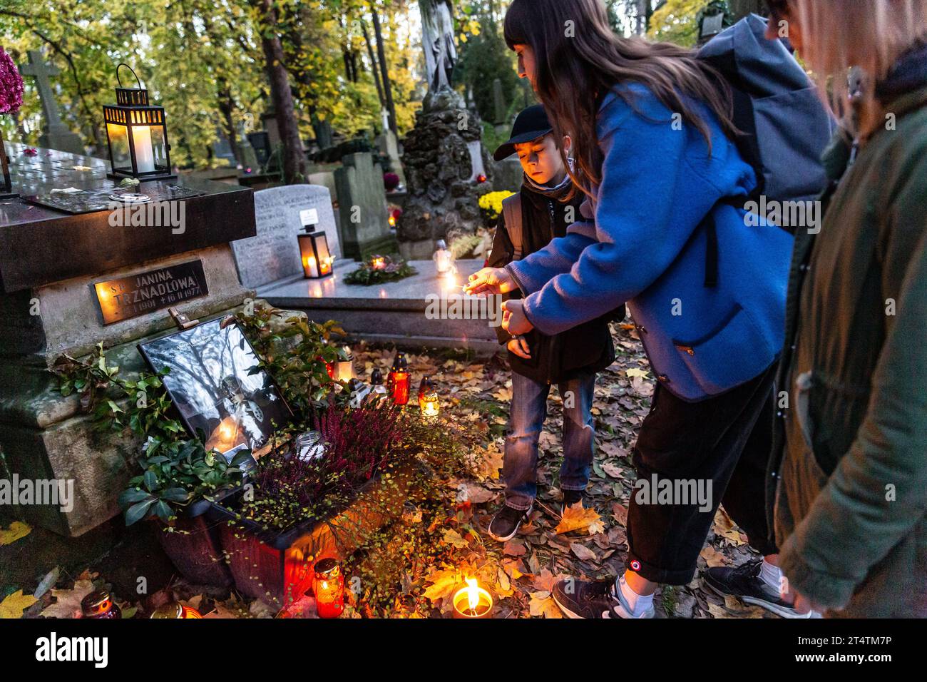 A family lights a candle at the landmark Rakowicki cemetery All Saints ...