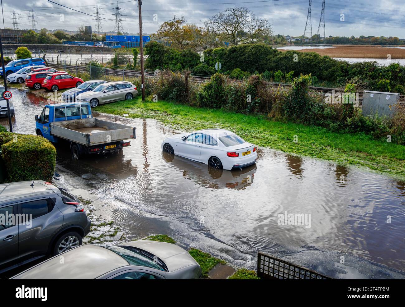 A broken down white BMW car stranded in a flooded road after heavy rainfall and high tide on the ...