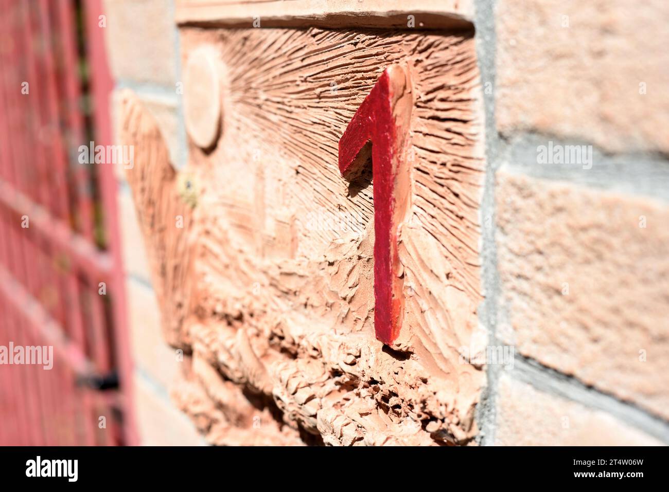 A red arrow is affixed to the side of a building, pointing outwards in ...