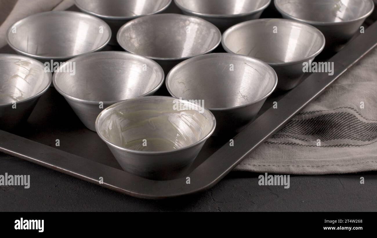 Baking forms smeared with butter prepared to egg tarts, traditional ...