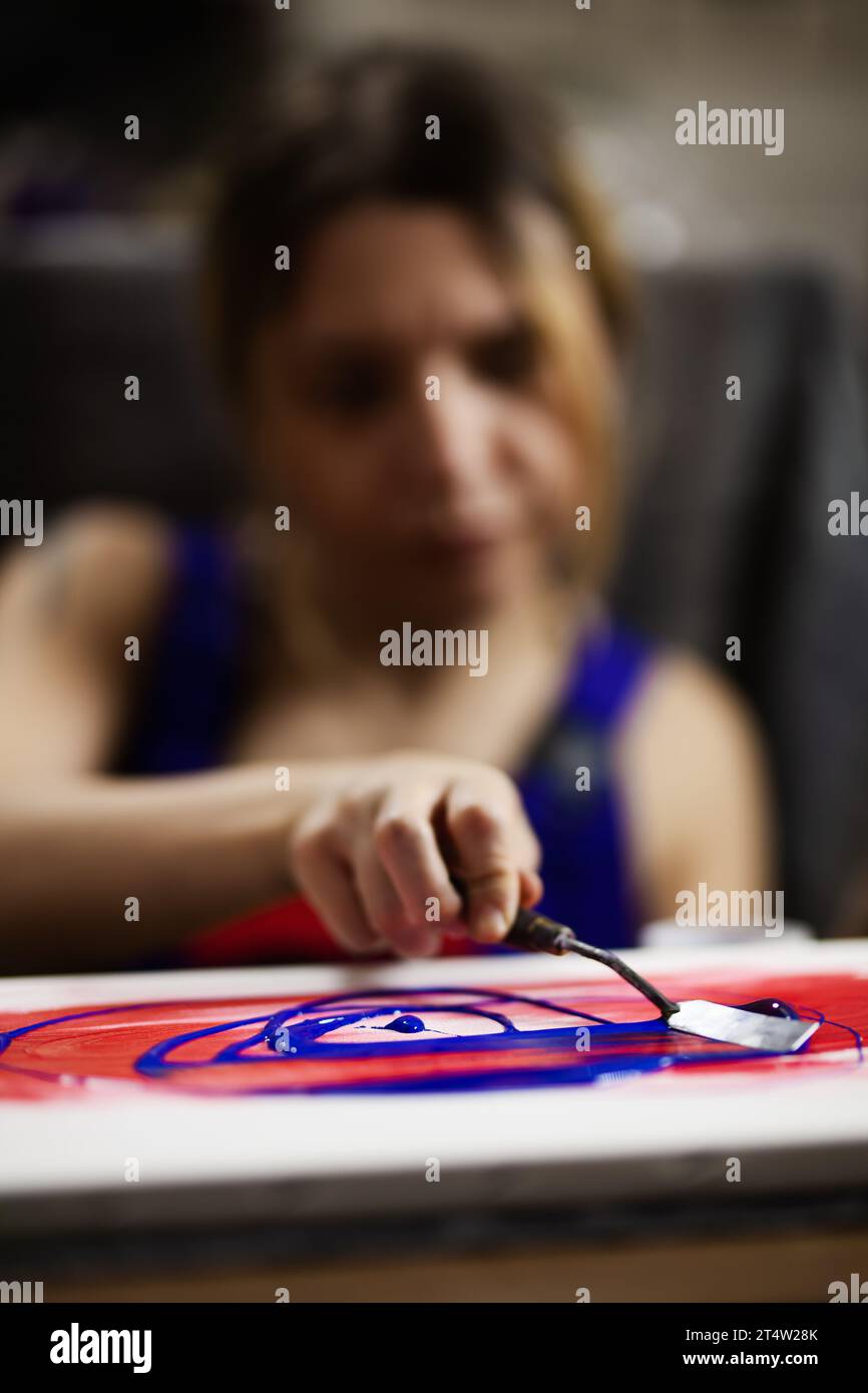Female artist making an artistic painting with a tool in her hand Stock ...