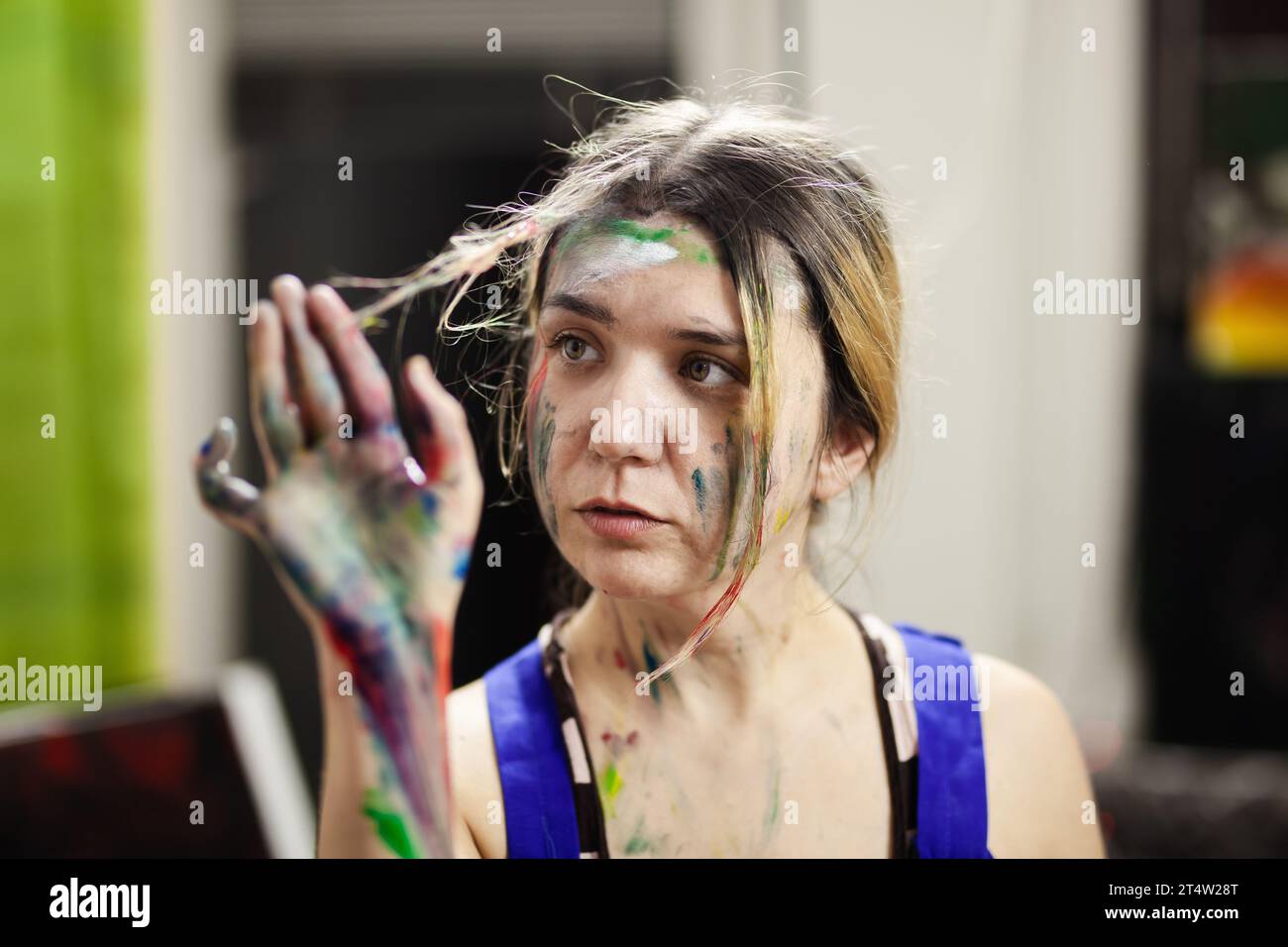 Portrait of a female artist. Girl with clumsy clorful painted face ...