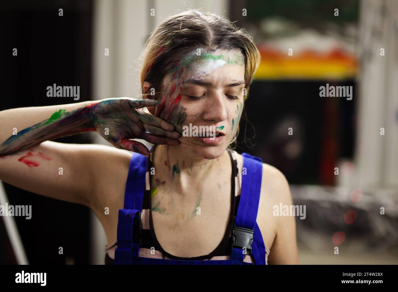 Portrait of a female artist. Girl with clumsy clorful painted face ...