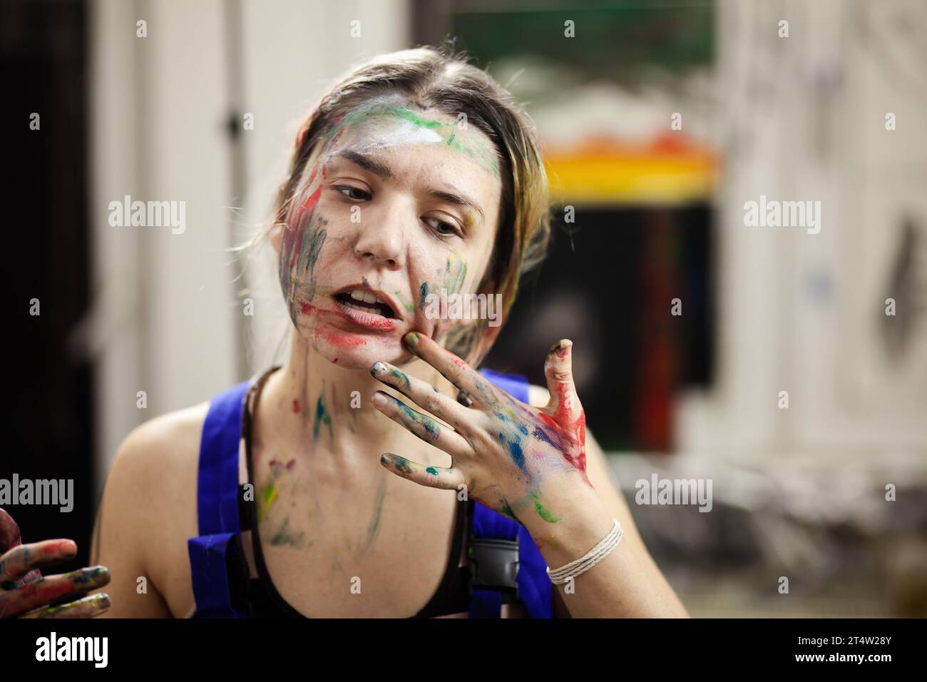 Portrait of a female artist. Girl with clumsy clorful painted face ...