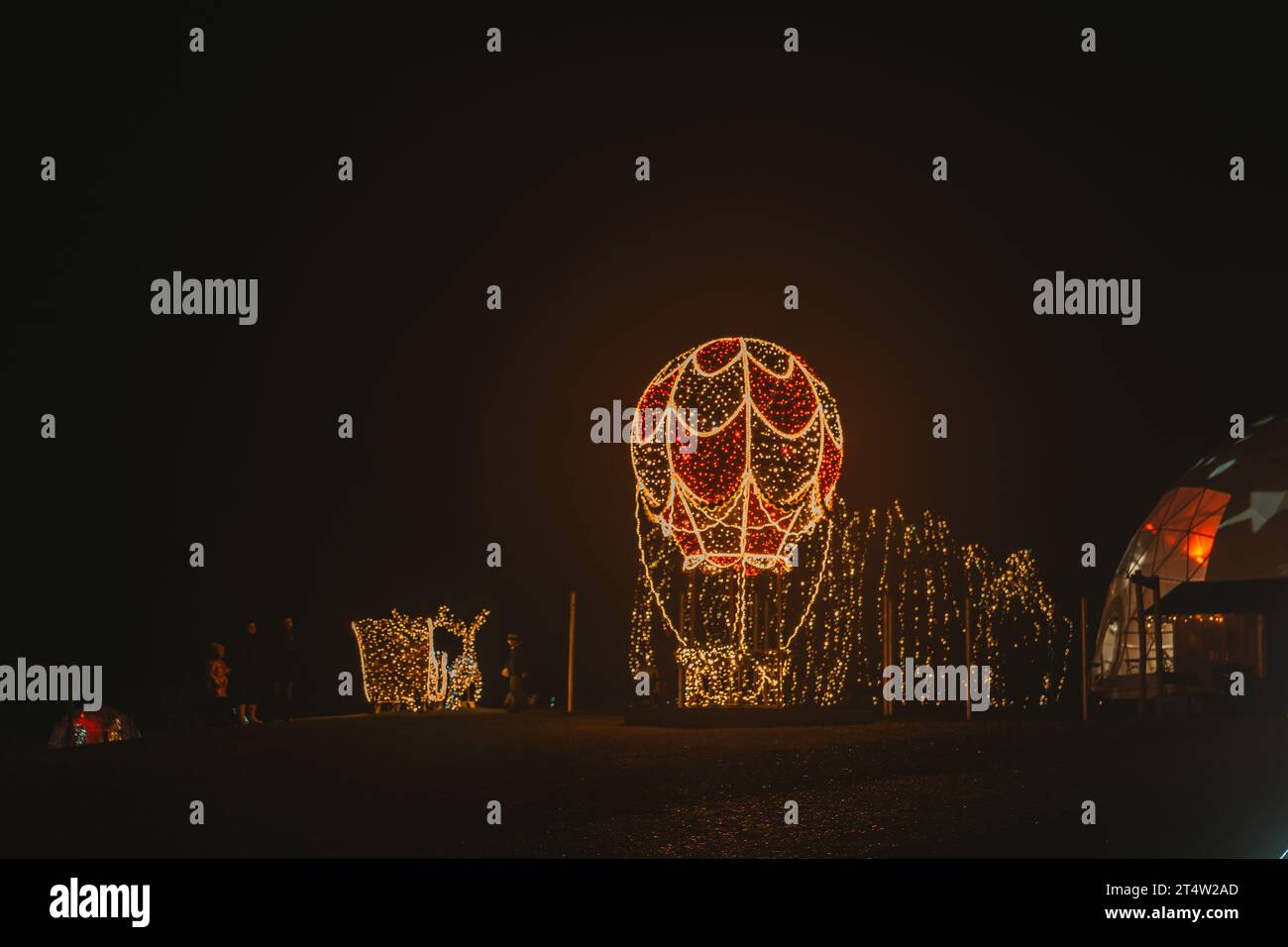 sparkling figure in the dark.Christmas street installation . Glowing ...