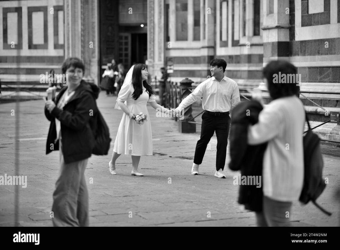A group of diverse people are walking together in a park, smiling and ...