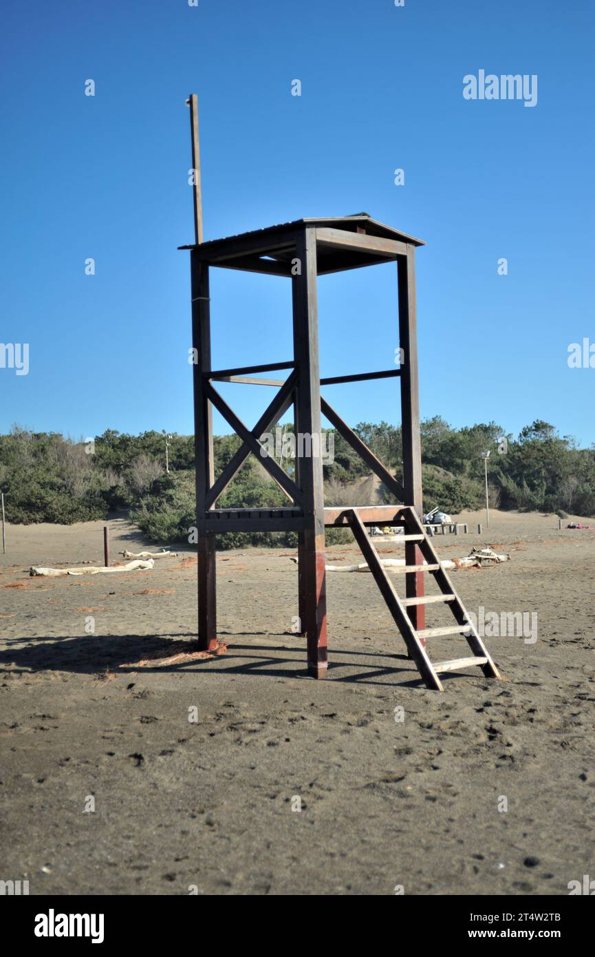 A daytime beach scene featuring a lifeguard chair and ladder set up on ...
