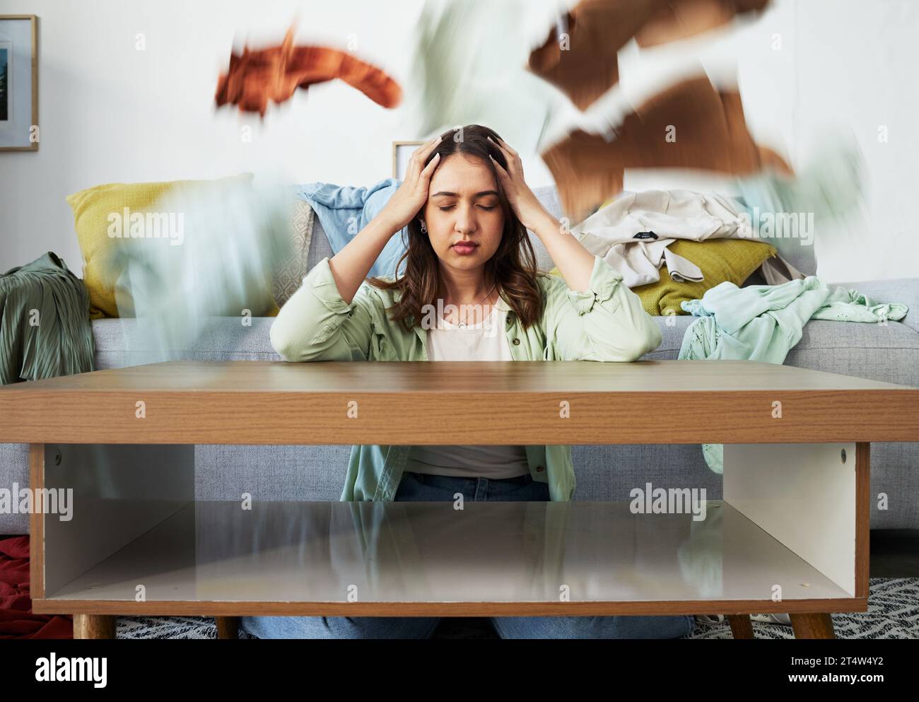 Headache, stress and woman with anxiety for laundry, clothes or ...