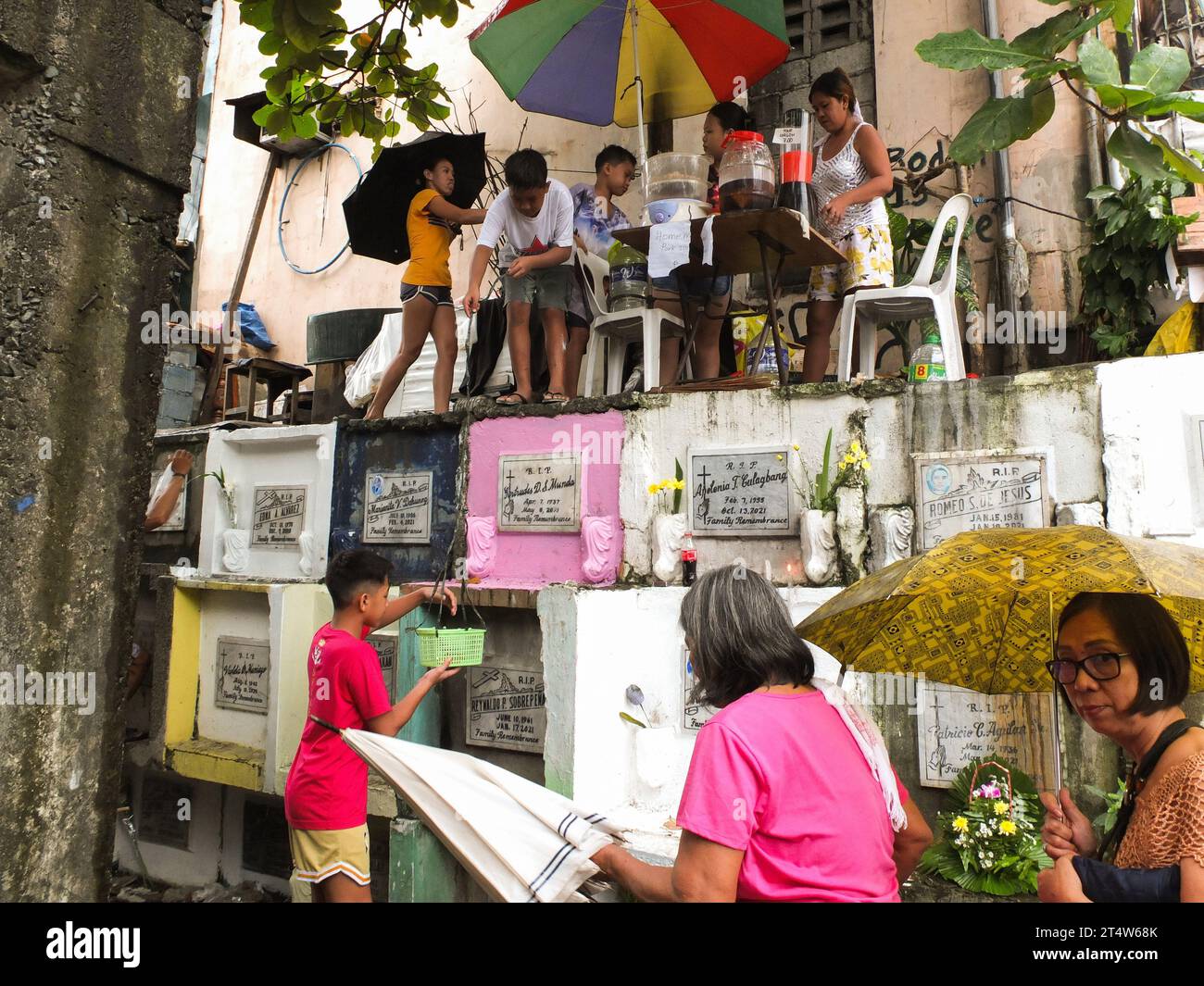 Caloocan, Philippines. 01st Nov, 2023. A young boy lowers a basket to ...
