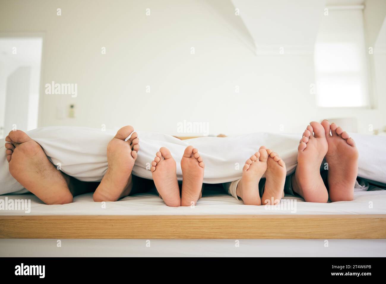 Sleep, feet and family in a bed relax, resting and enjoying a weekend ...