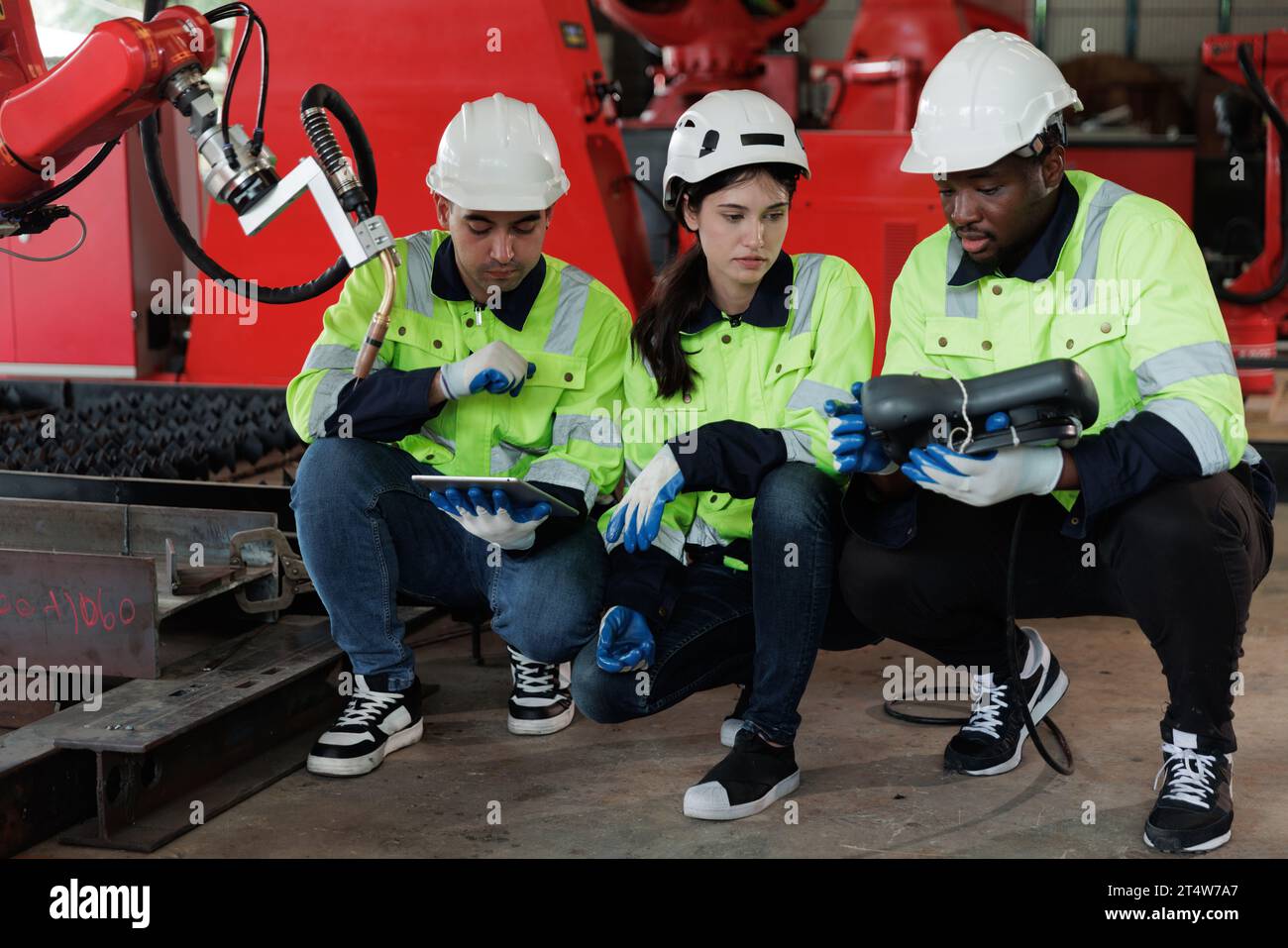 Engineer grop controlling and checking robot arm at factory. Technology ...