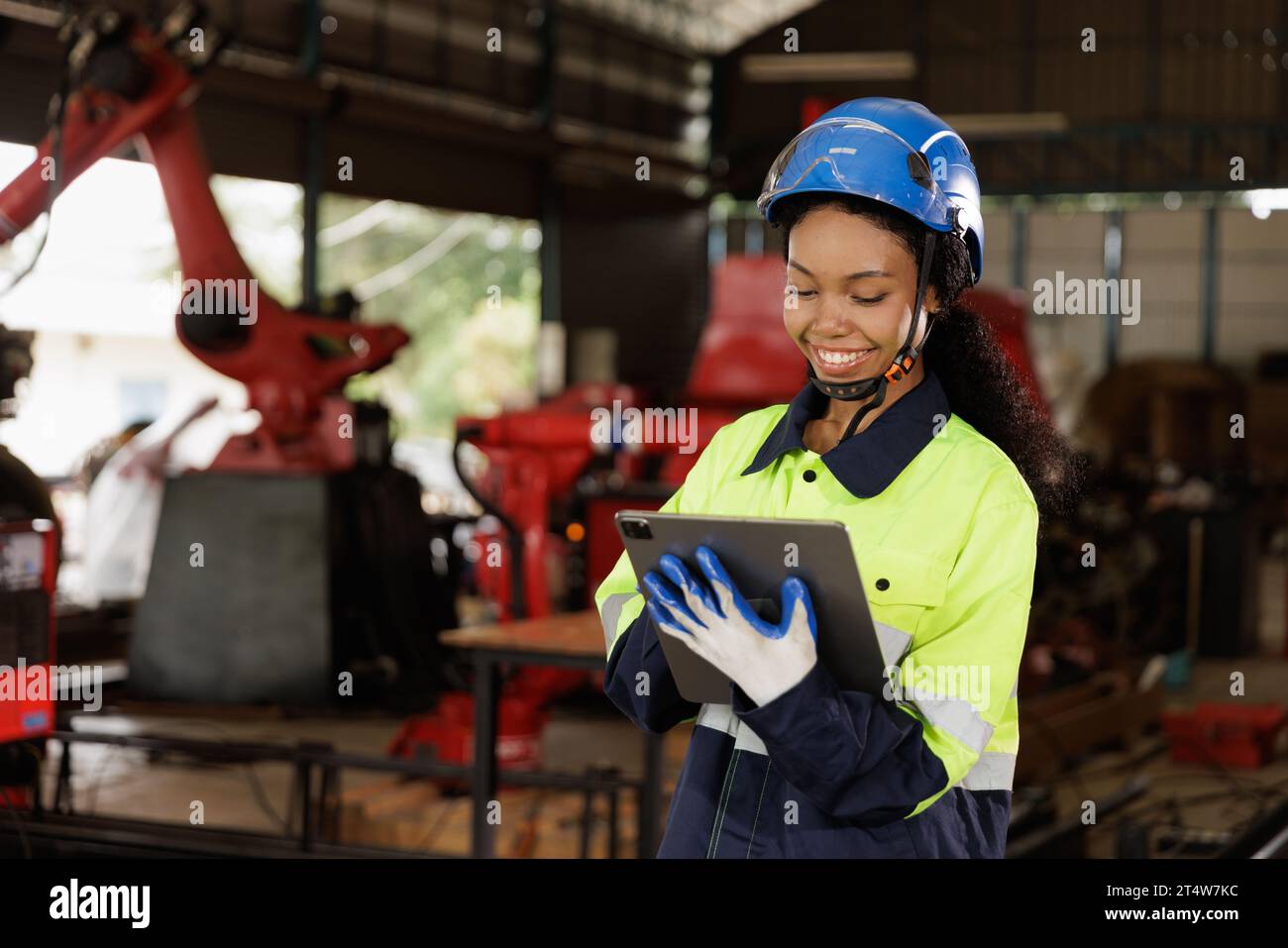 Portrait of female mechanical engineer worker in yellow hard hat and ...