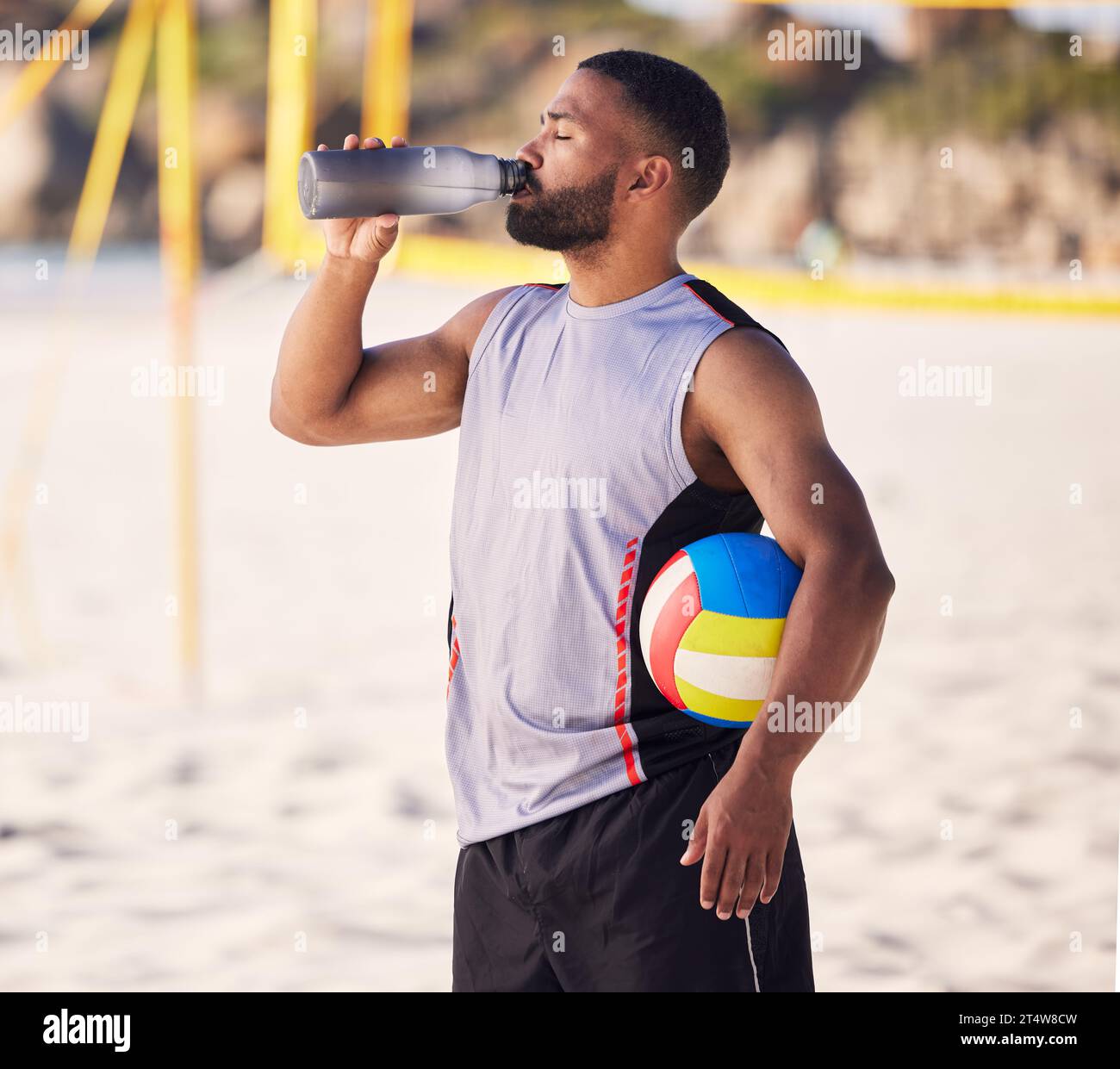 Volleyball, drinking water and fitness of man on beach for training ...