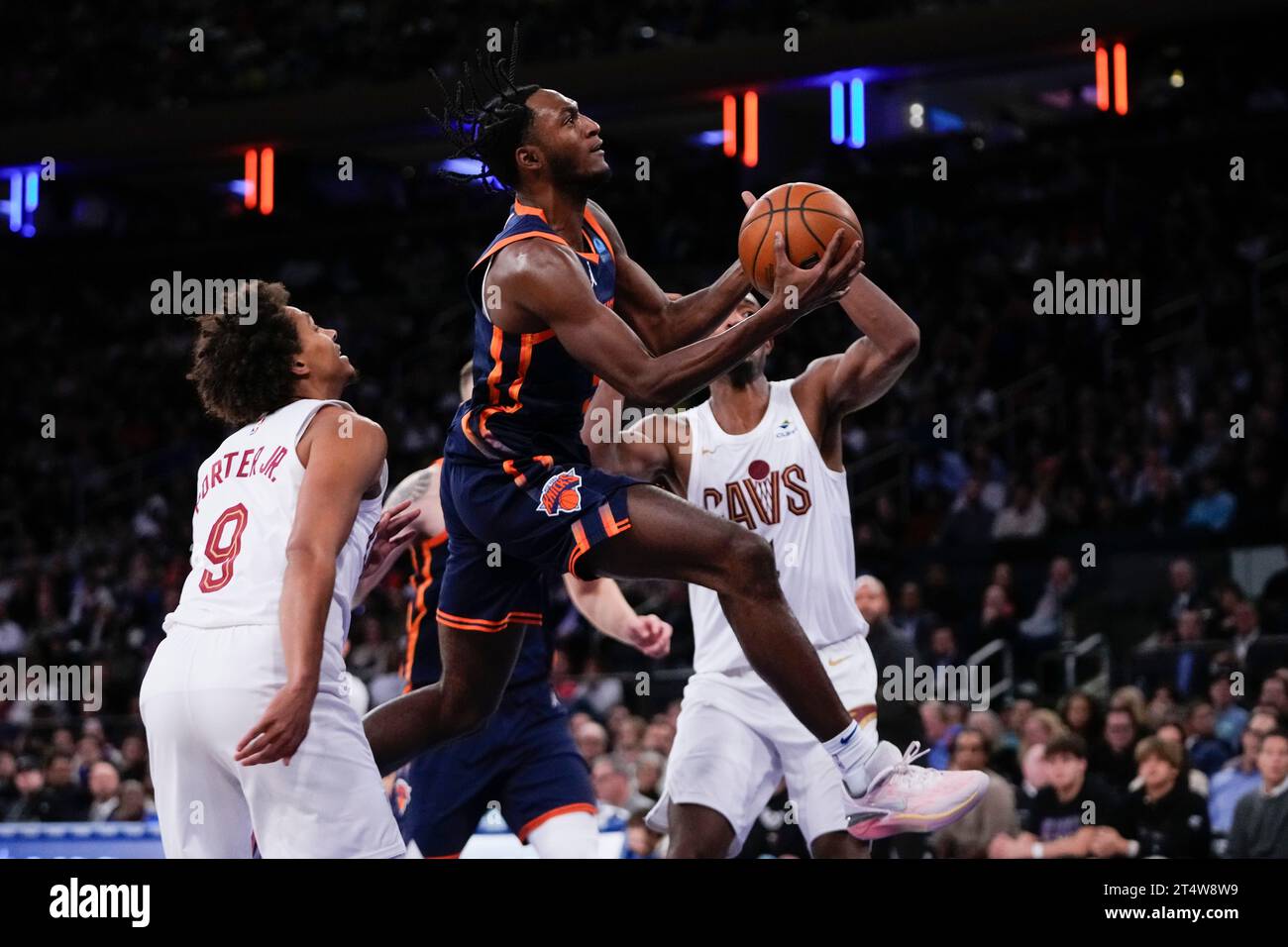 New York Knicks' Immanuel Quickley, center, drives past Cleveland ...