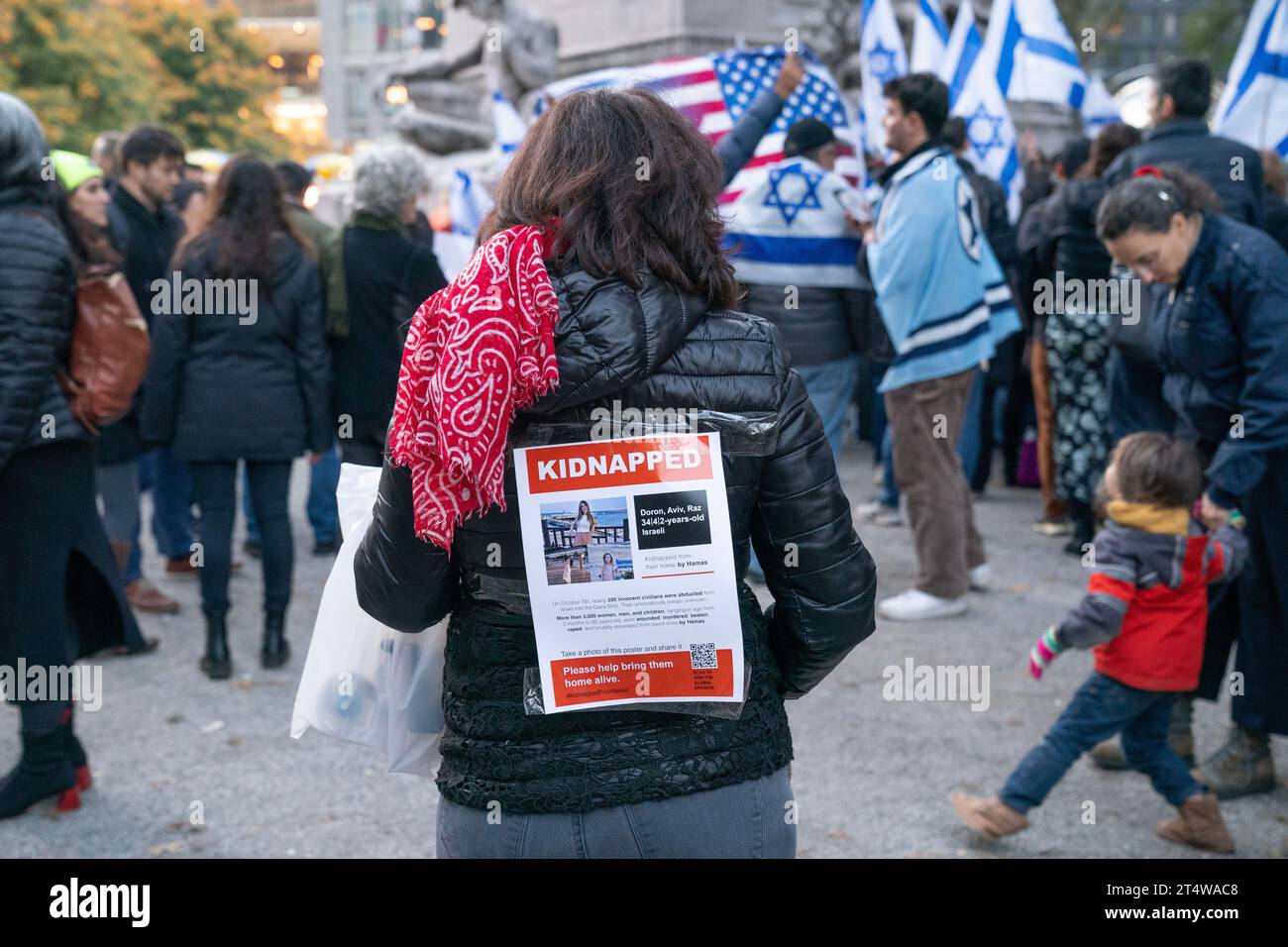 Woman seen with poster attached to her back at rally for release ...