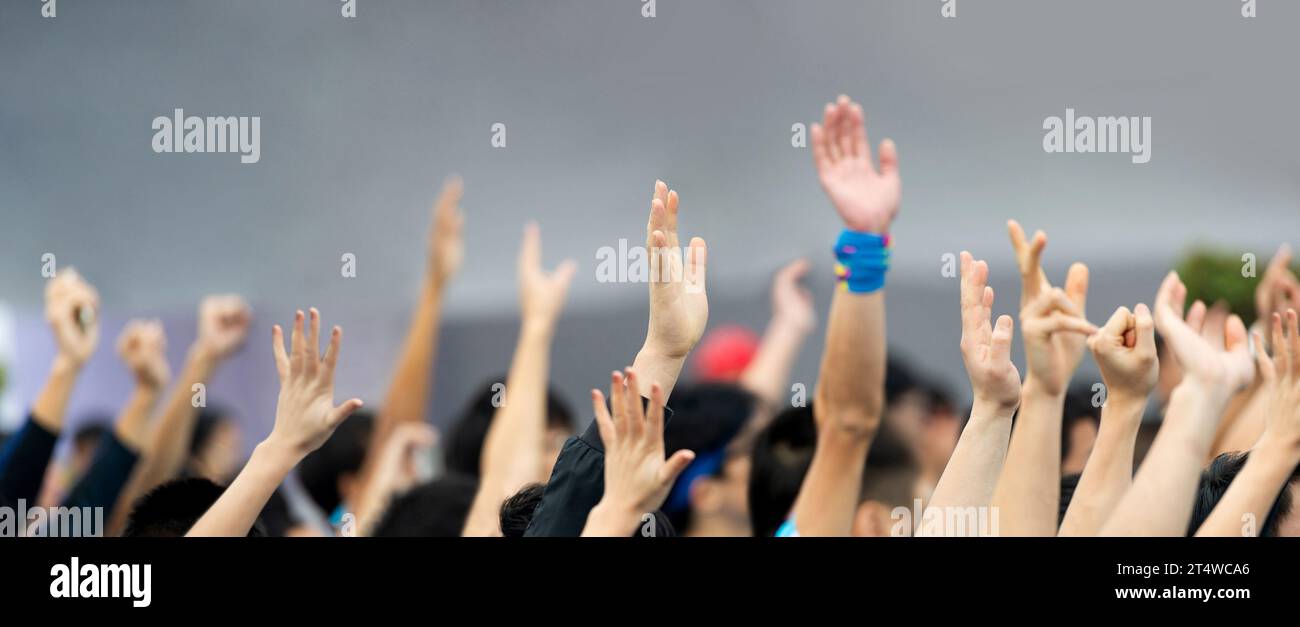 Many hands raised in a crowd of people Stock Photo - Alamy