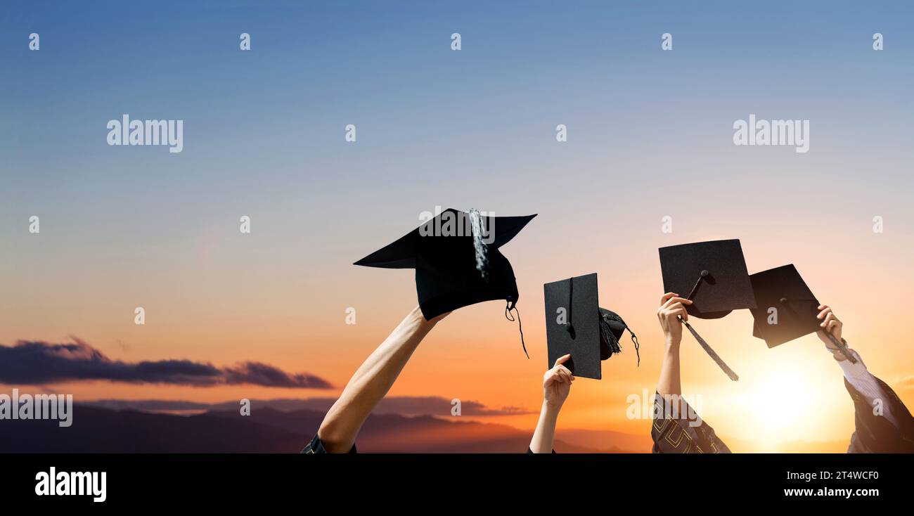 Four hands holding graduation hats against sunrise sky Stock Photo - Alamy