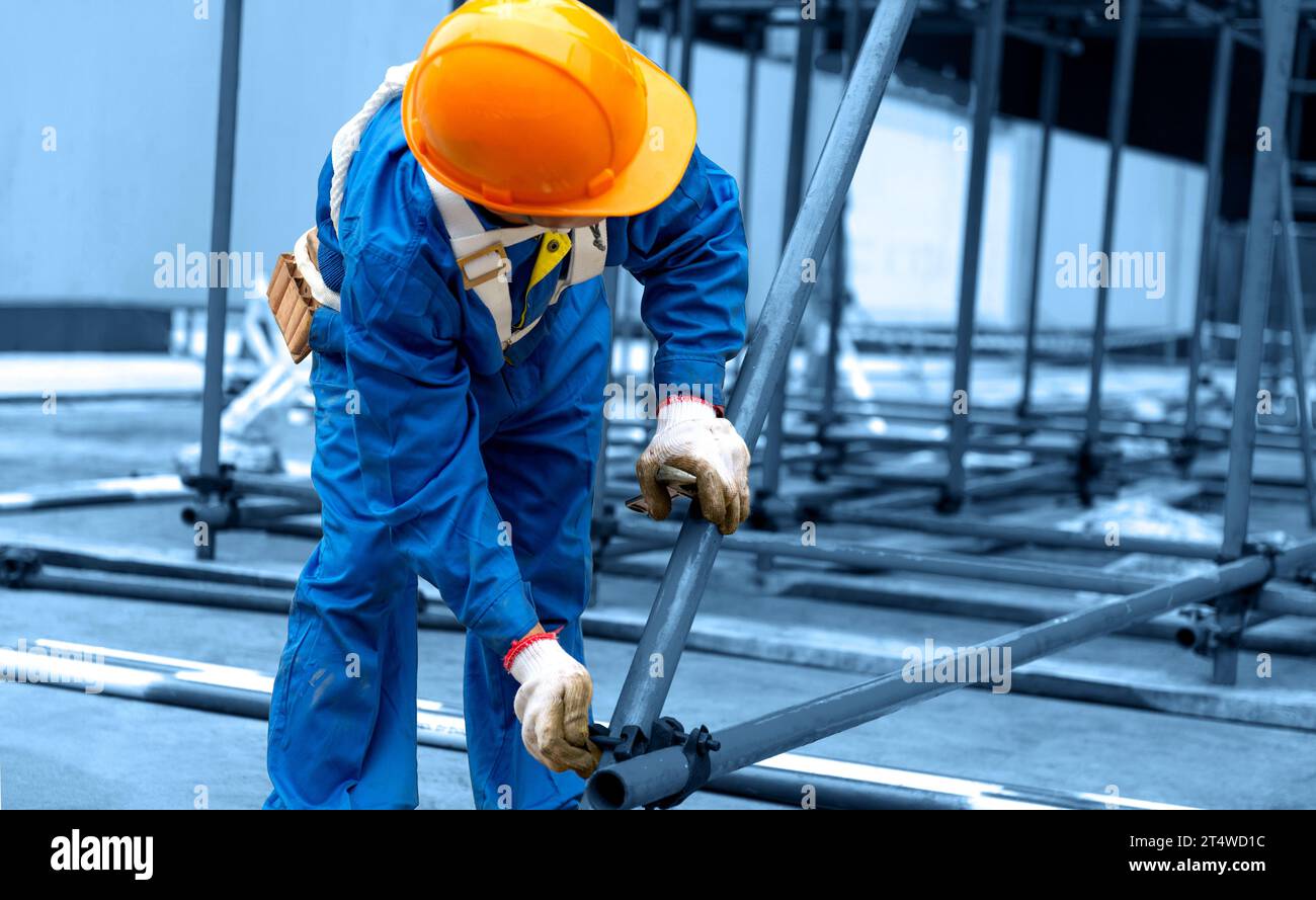 Single construction worker working on scaffolding Stock Photo - Alamy