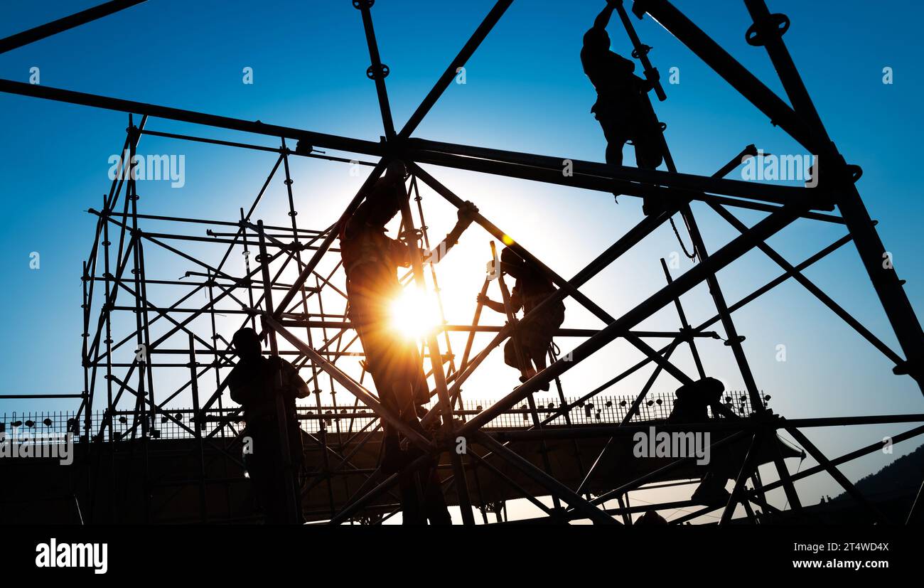 Group of construction workers working on scaffolding Stock Photo - Alamy