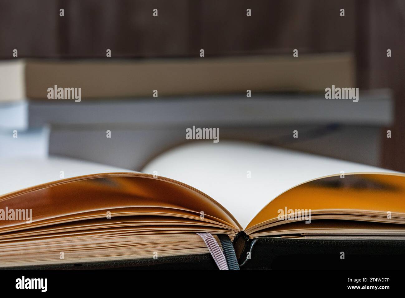 A closeup image of an open book on a desk, with the cover page and ...