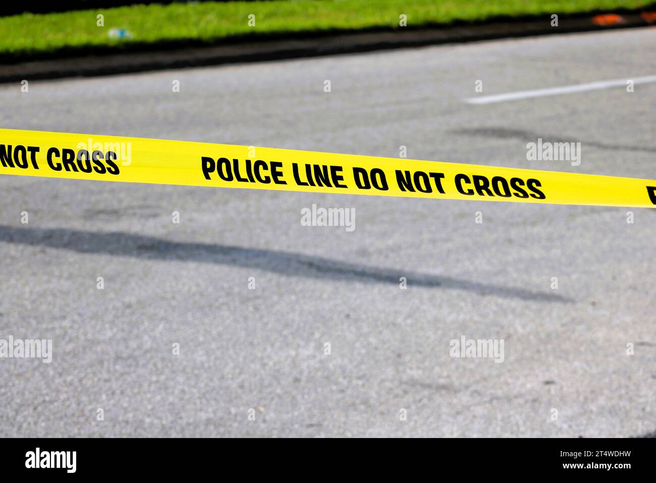 a city street with a bright yellow police line labeled 'Do Not Cross ...