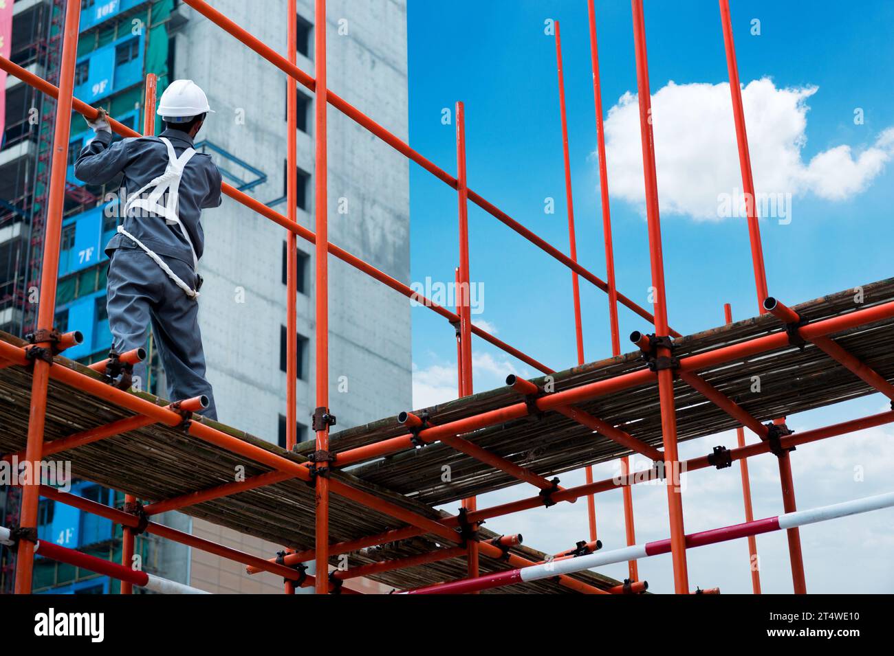Single construction worker working on scaffolding Stock Photo - Alamy