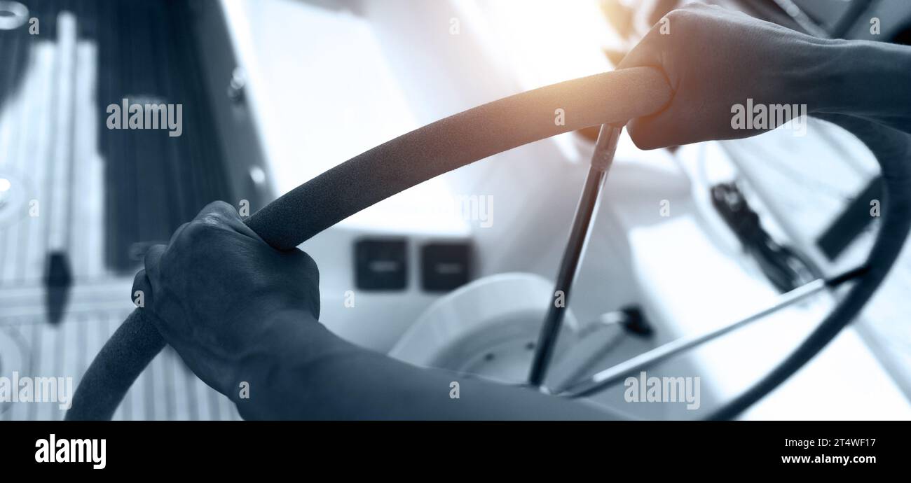 Captain at the helm of a sailboat Stock Photo - Alamy