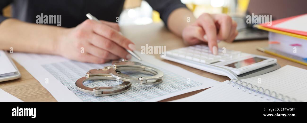 Handcuffs on investigation paper while woman making counts Stock Photo ...