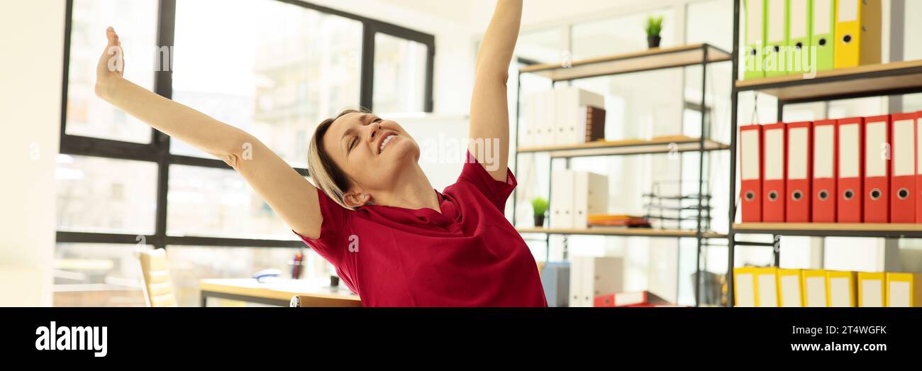 Happy woman stretches back and arms after finishing report Stock Photo ...