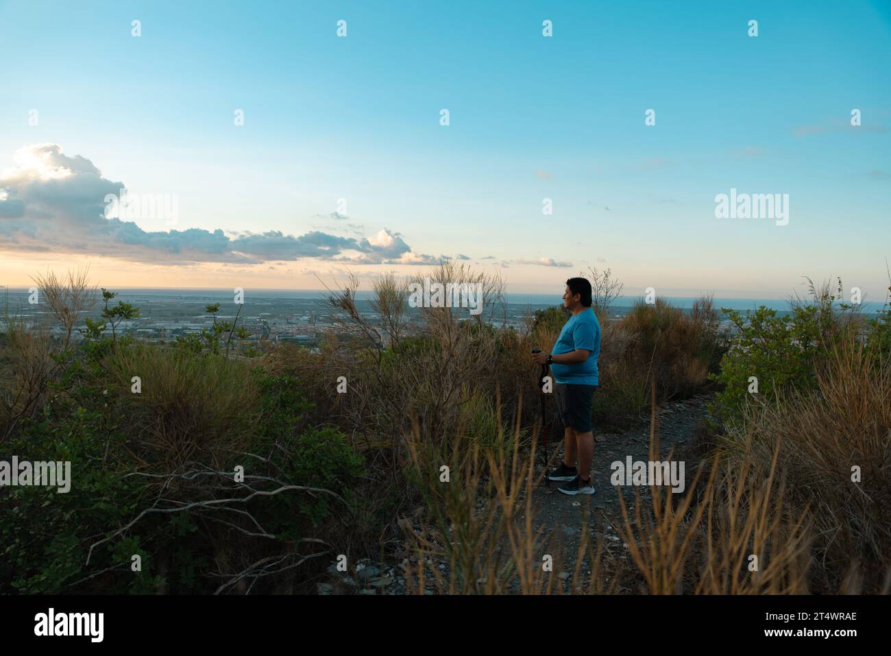Overweight man stops his training to contemplate the landscape in the ...
