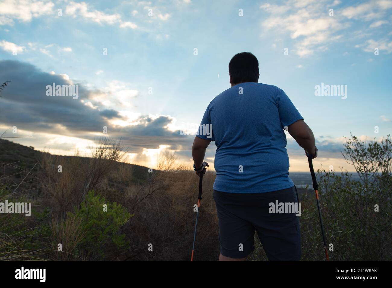 Overweight man stops his training to contemplate the landscape in the ...