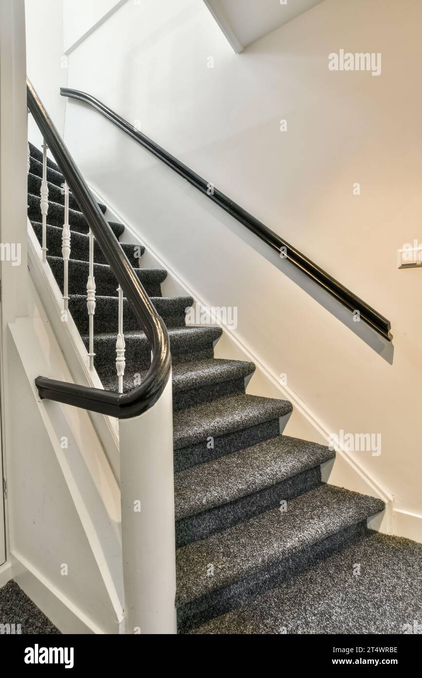 some stairs in a house that is white and has grey carpet on the floor ...