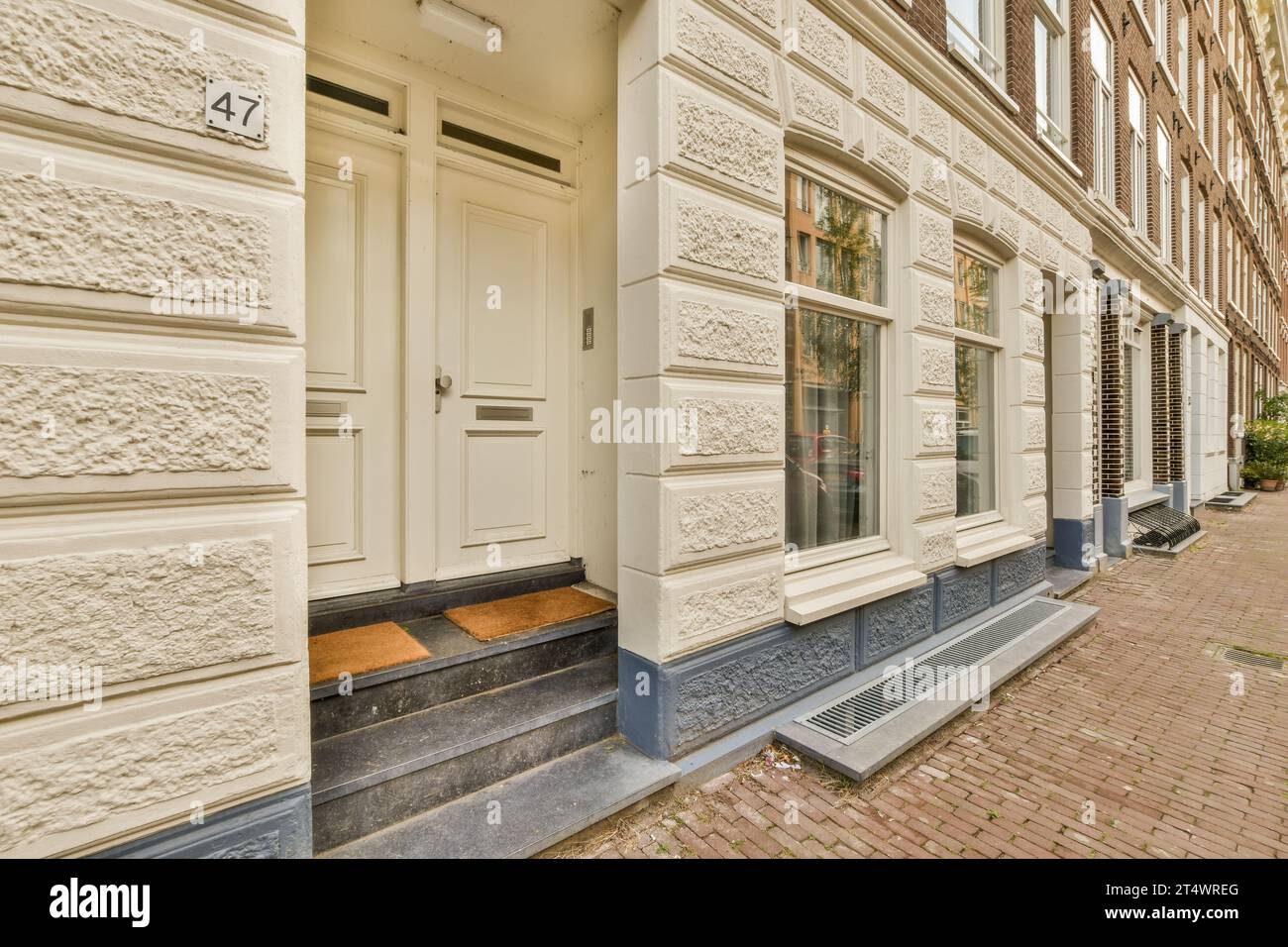 a bricked building with white trim on the front door and two windows in ...