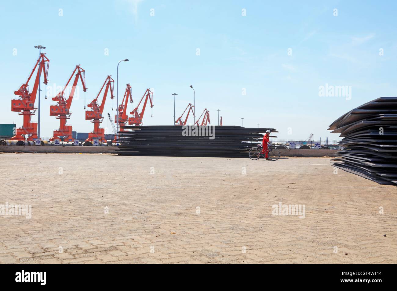 Portal crane and steel plates at freight terminals Stock Photo - Alamy