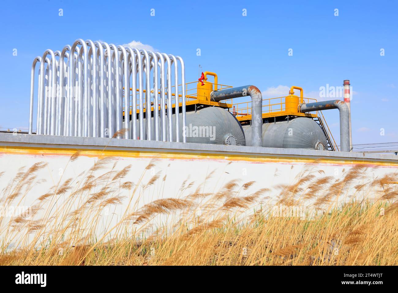 Silver metal radiator and storage tanks under blue sky Stock Photo - Alamy