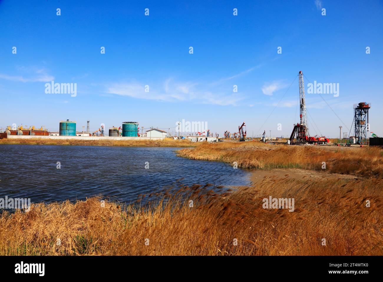 Oil storage tanks and pond under blue sky Stock Photo - Alamy