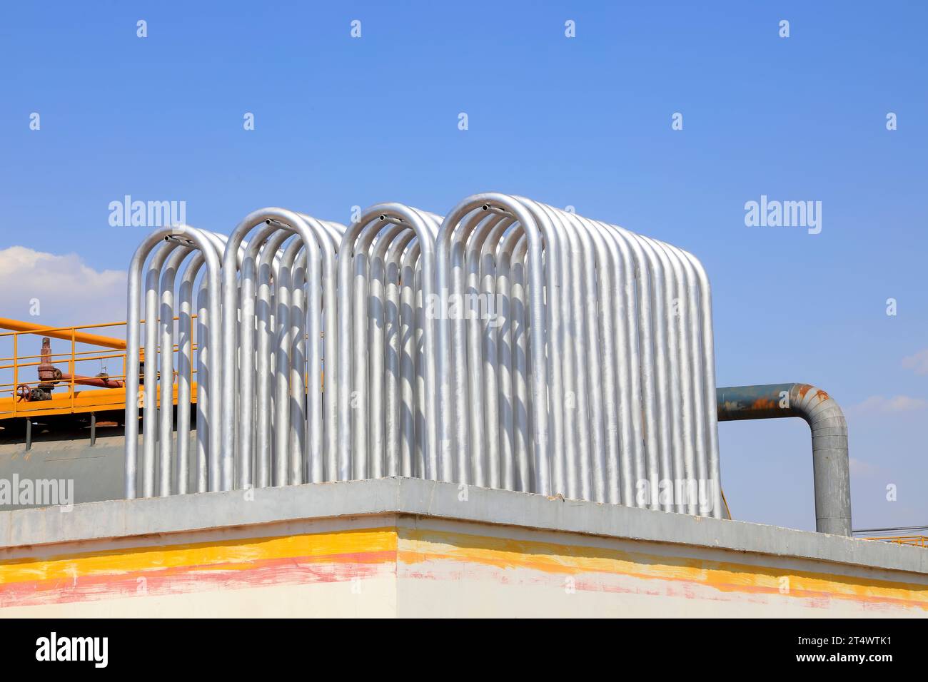 Silver metal radiator and storage tanks under blue sky Stock Photo - Alamy
