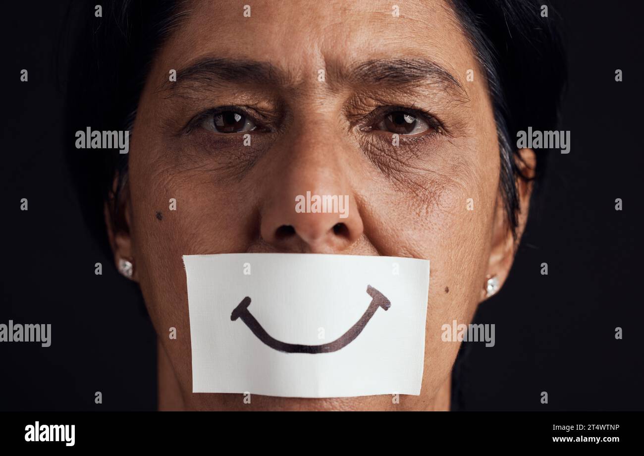 Portrait, smile or anxiety and a mature woman in studio on a dark ...